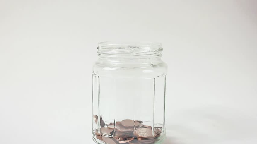 Coins Fall Into Clear Jar In Slow Motion. A Clear Jar Fills Up With ...