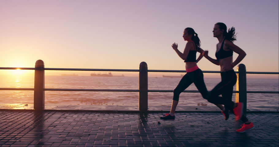 Two Athletic Woman Running Outdoors In Slow Motion On Promenade At ...