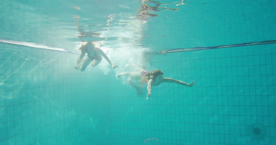 Young Female Friends In A Swimming Pool Having Fun Together Underwater ...