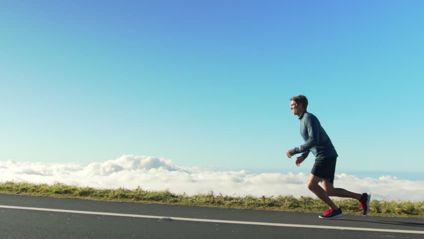 Stock Video Clip of Young Man Running on Mountain Road at | Shutterstock