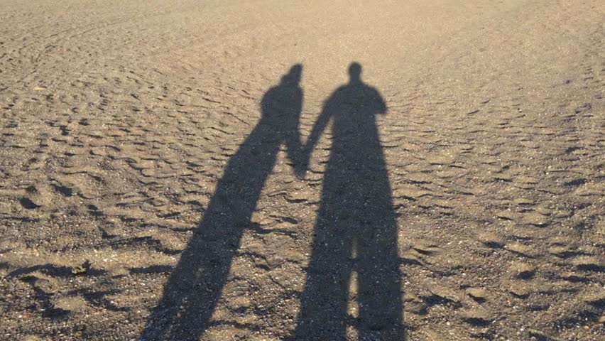 Stock Video Clip of Lovers shadows on the beach. Young couple's ...