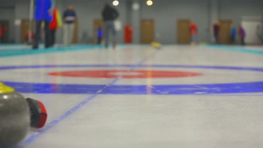Curling Player Delivering A Stone On A Curling Rink, Sliding Over The ...