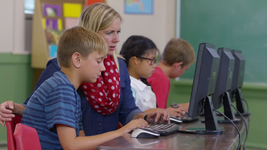 Elementary School Student And Teacher Look At Computer วิดีโอสต็อก ...