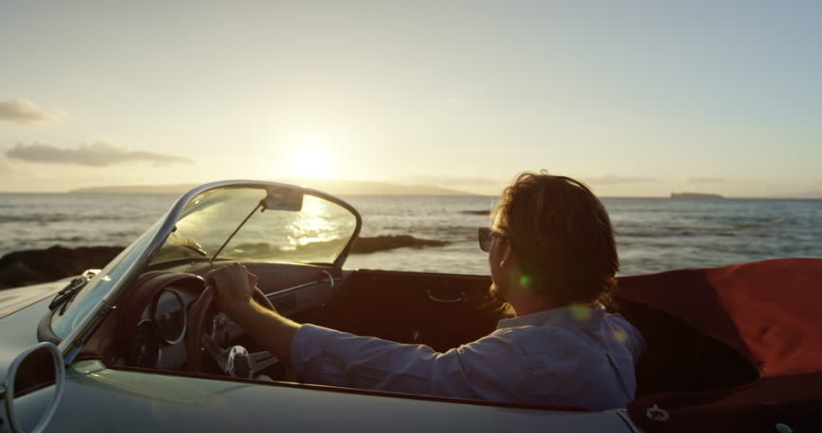 Happy Couple Driving Into Sunset In Classic Vintage Sports Car By The ...