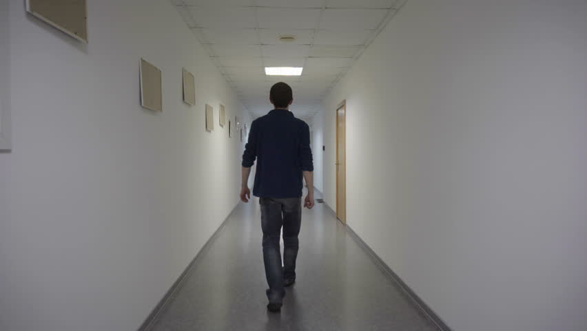 A Man Walking In A Dark Room With A Strong Light Coming From Behind ...