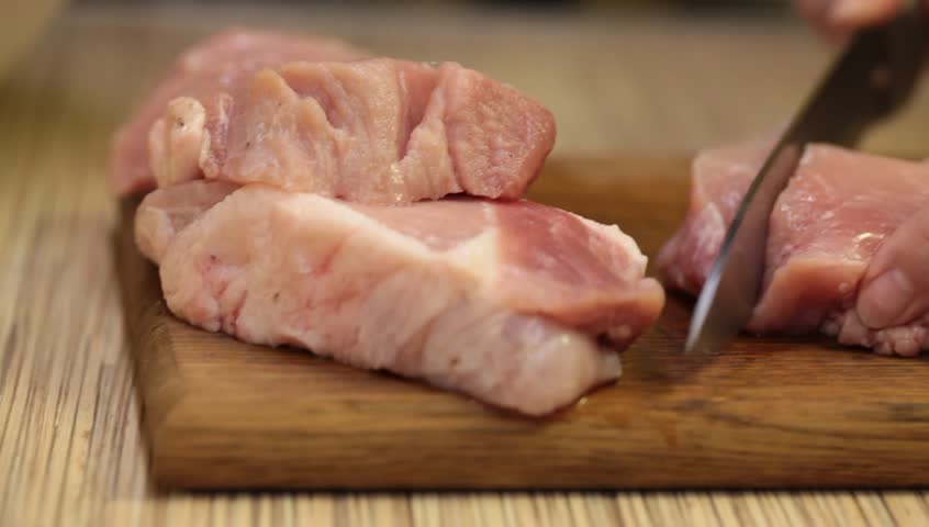 Person's Hands Cutting Into A Large Piece Of Raw Meat Using A Butcher's ...