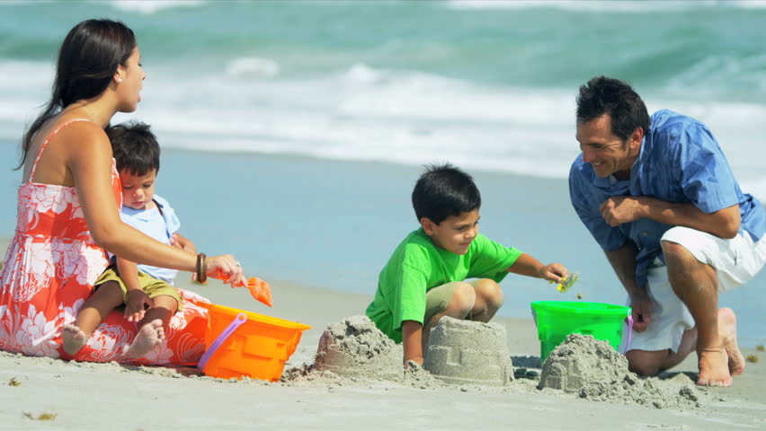 Loving Hispanic Family Spending Summer Vacation Playing On Sandy Beach ...