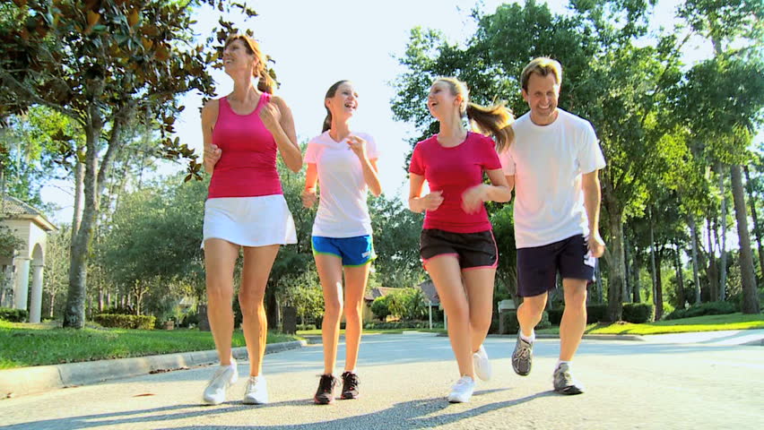 Group Of Men And Women Running Past Camera Position On Urban Street ...