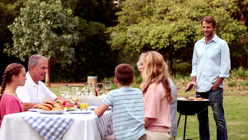 Stock Video Clip of Family eating outdoors and preparing the barbecue ...