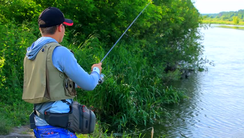 Sport Fisherman Fishing On A River Bank With Fishing Rod,video Clip ...