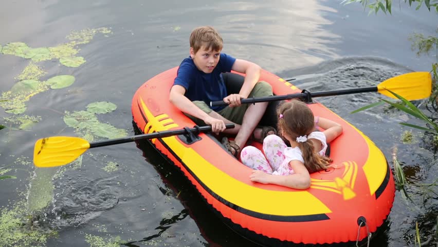 Boy And Girl Float In Inflatable Boat With Oars On Pond. Stock Footage ...