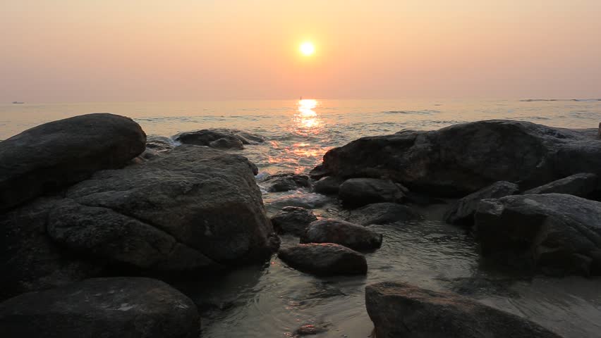 Stock video of sunrise over rocks on the beach | 8799298 | Shutterstock
