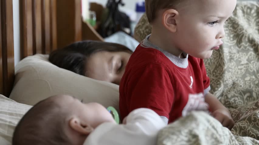 A Tired Single Mother Lying In Bed With Sick Children In The Morning ...